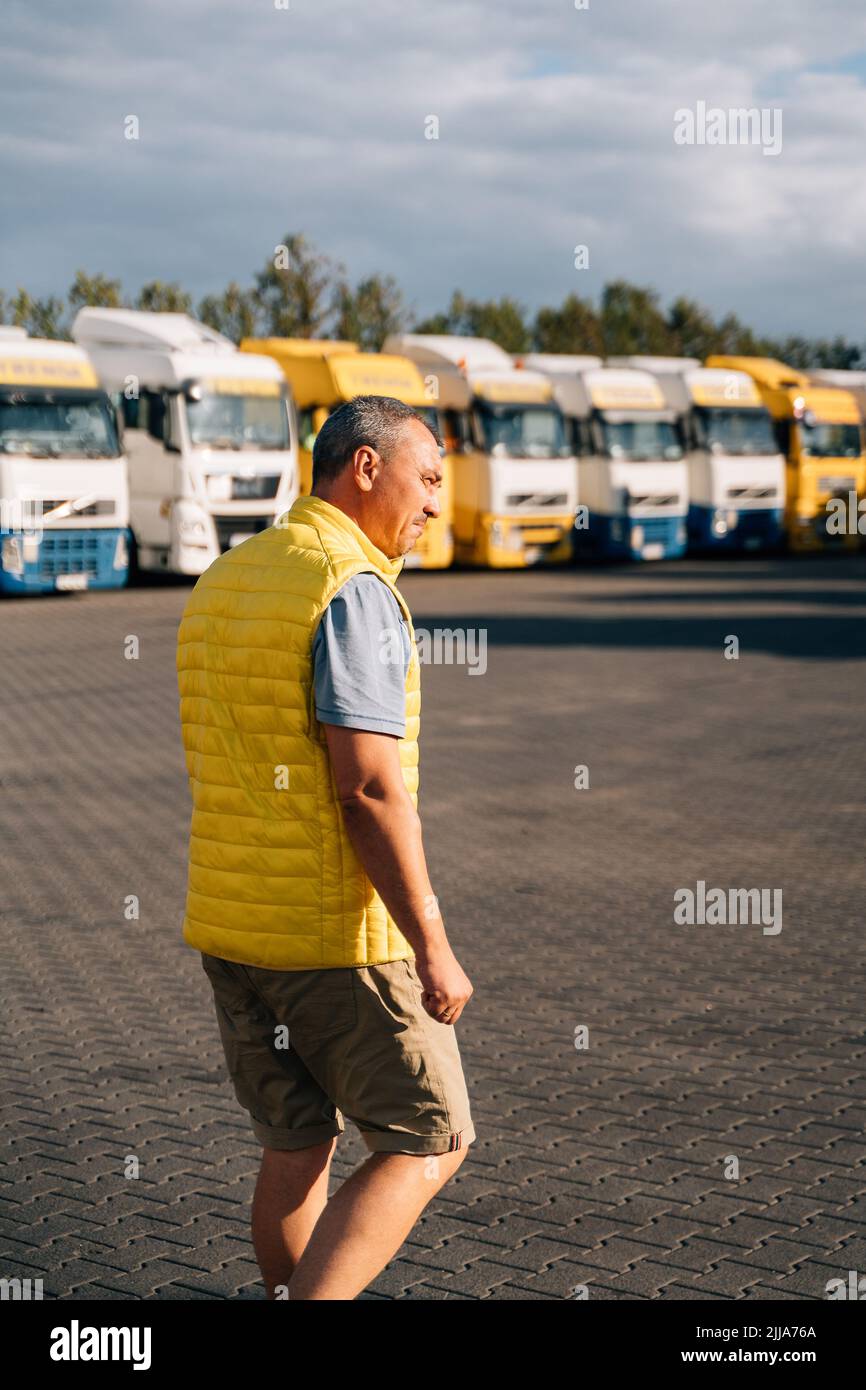Portrait of caucasian mature man on semi-truck vehicles parking ...