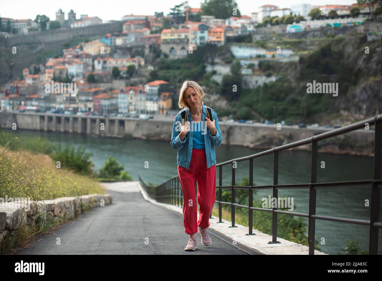 A woman tourist tired of climbing a mountain. In the background in a ...