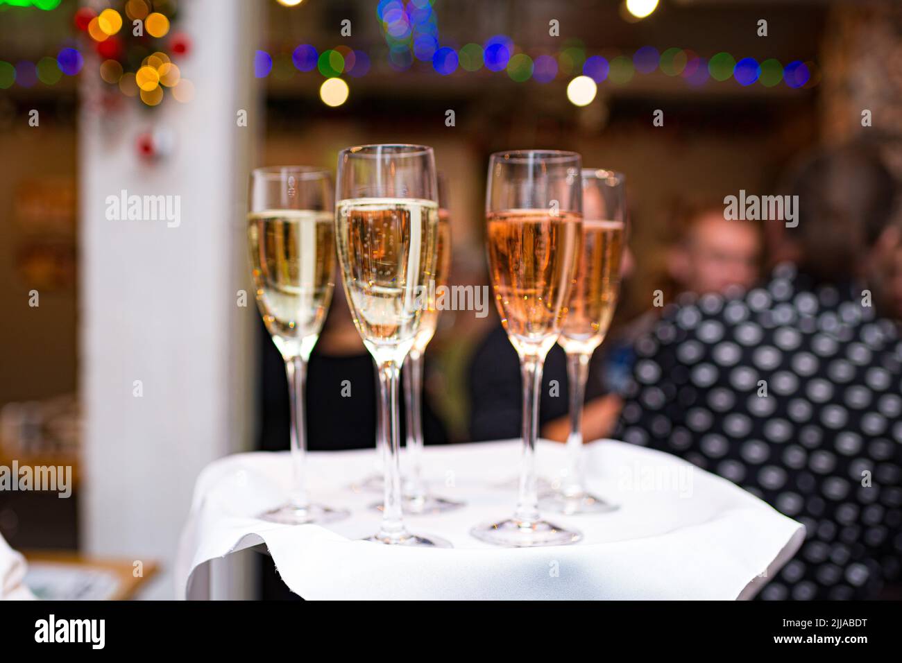 Champagne glasses on the waiter's tray. Serving alcoholic beverages at ...