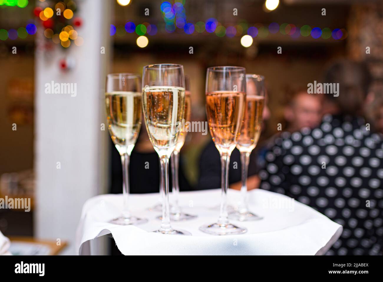 Champagne glasses on the waiter's tray. Serving alcoholic beverages at ...