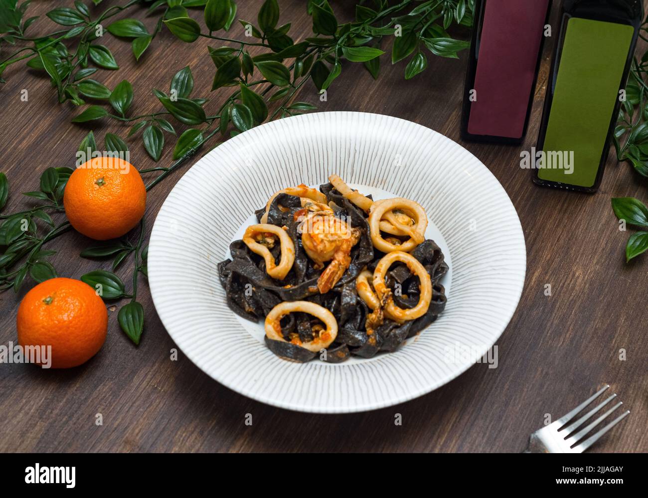 black pasta with cuttlefish ink and seafood (shrimps and squid rings ...