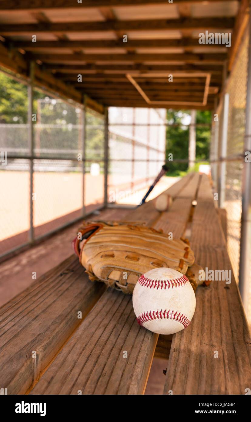 Baseball and glove on dugout bench with blurred background Stock Photo ...