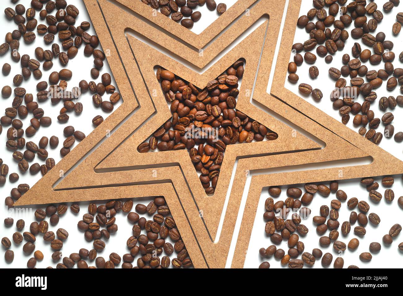 Roasted coffee beans shaping star on white background Stock Photo - Alamy