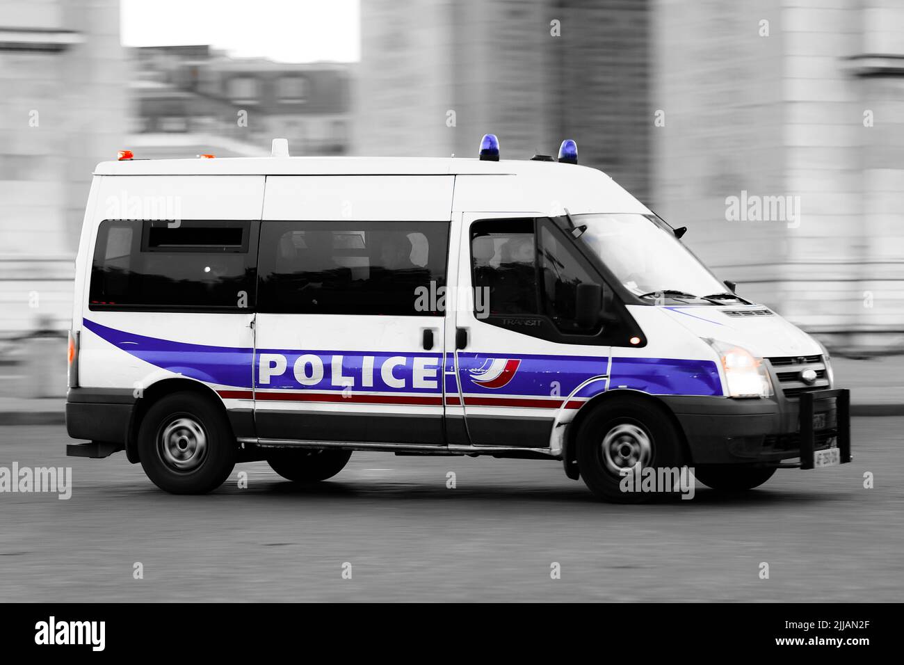 A police car (truck, van) drives through the city ensuring security in ...