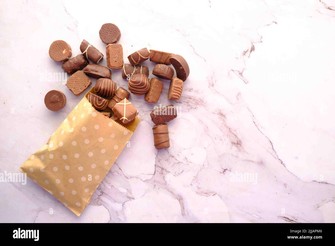dark chocolate spilling form a paper packet Stock Photo - Alamy
