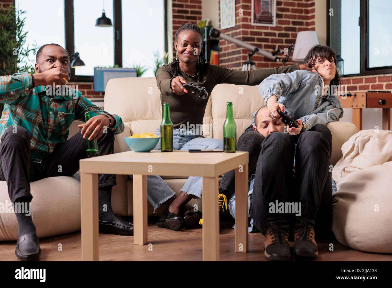 Diverse group of happy friends playing video games on tv console, using ...