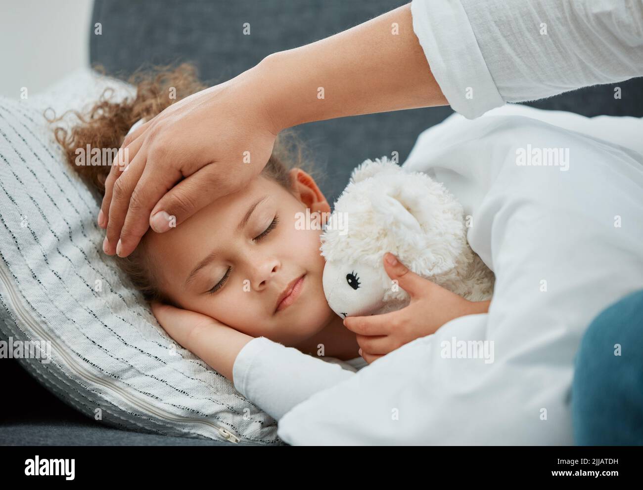 My poor baby is so unwell. a father checking his daughter for a fever ...