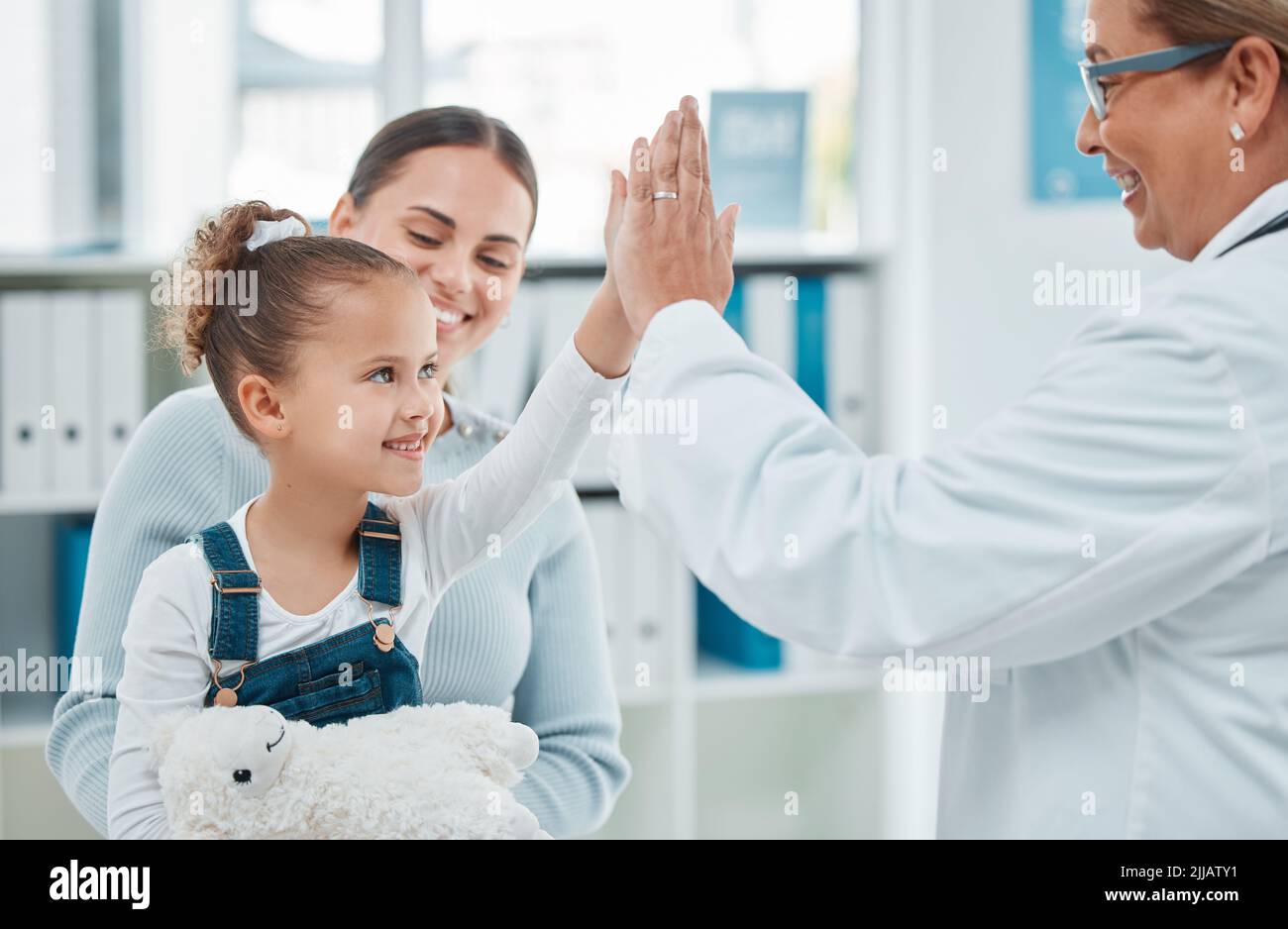 Theres nothing to be scared of. a little girl giving a doctor a high ...