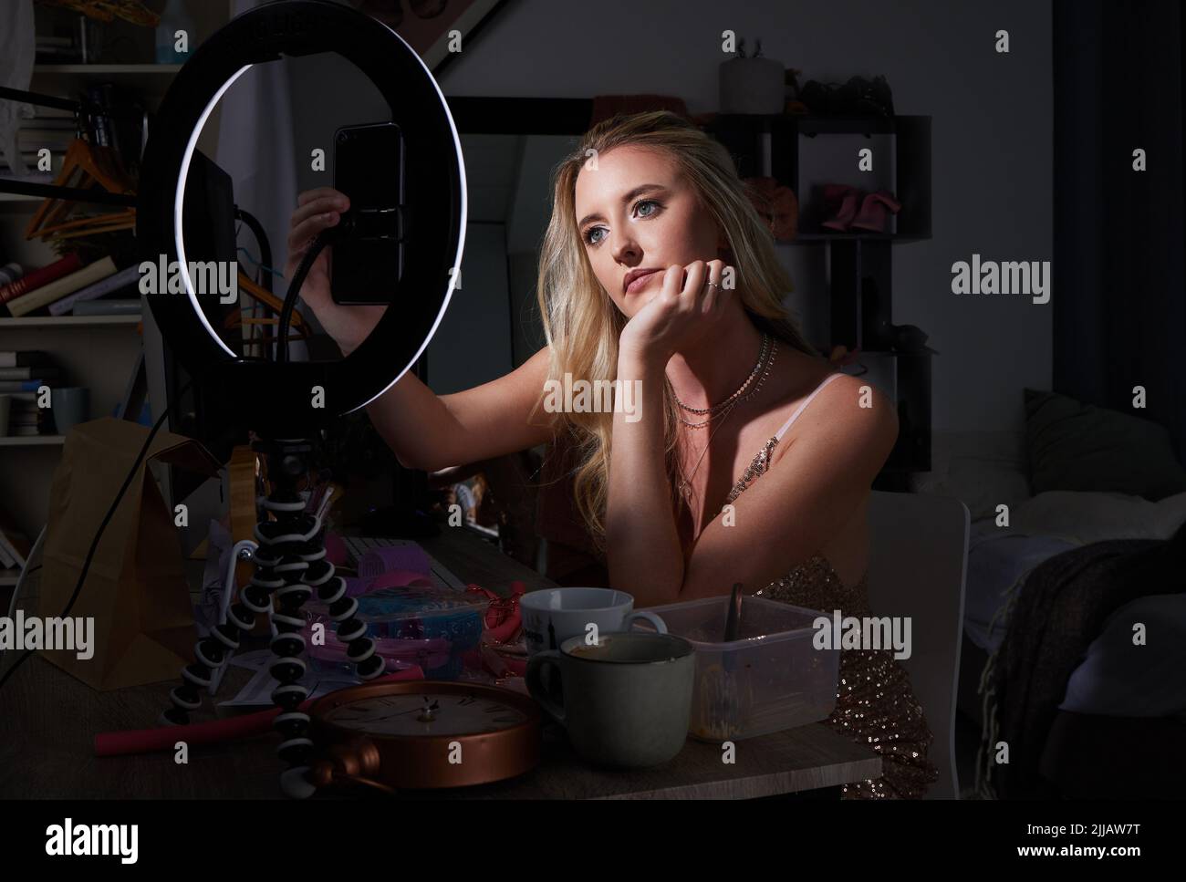 Setting up for a shoot. an attractive young female influencer recording ...