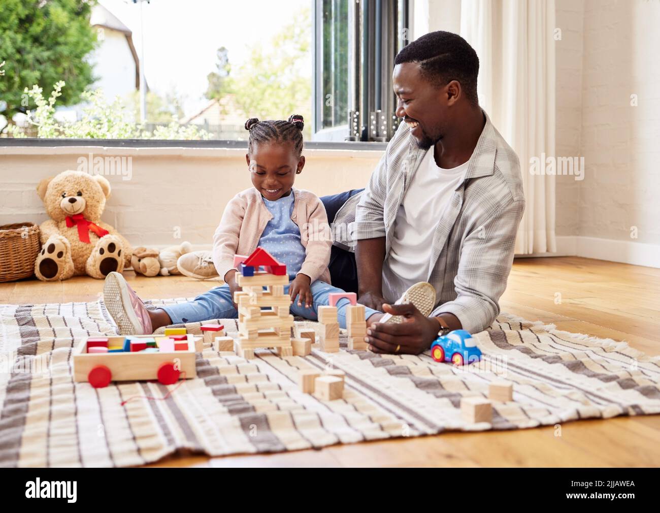 Admiring her masterpiece. a little girl playing with blocks with her ...