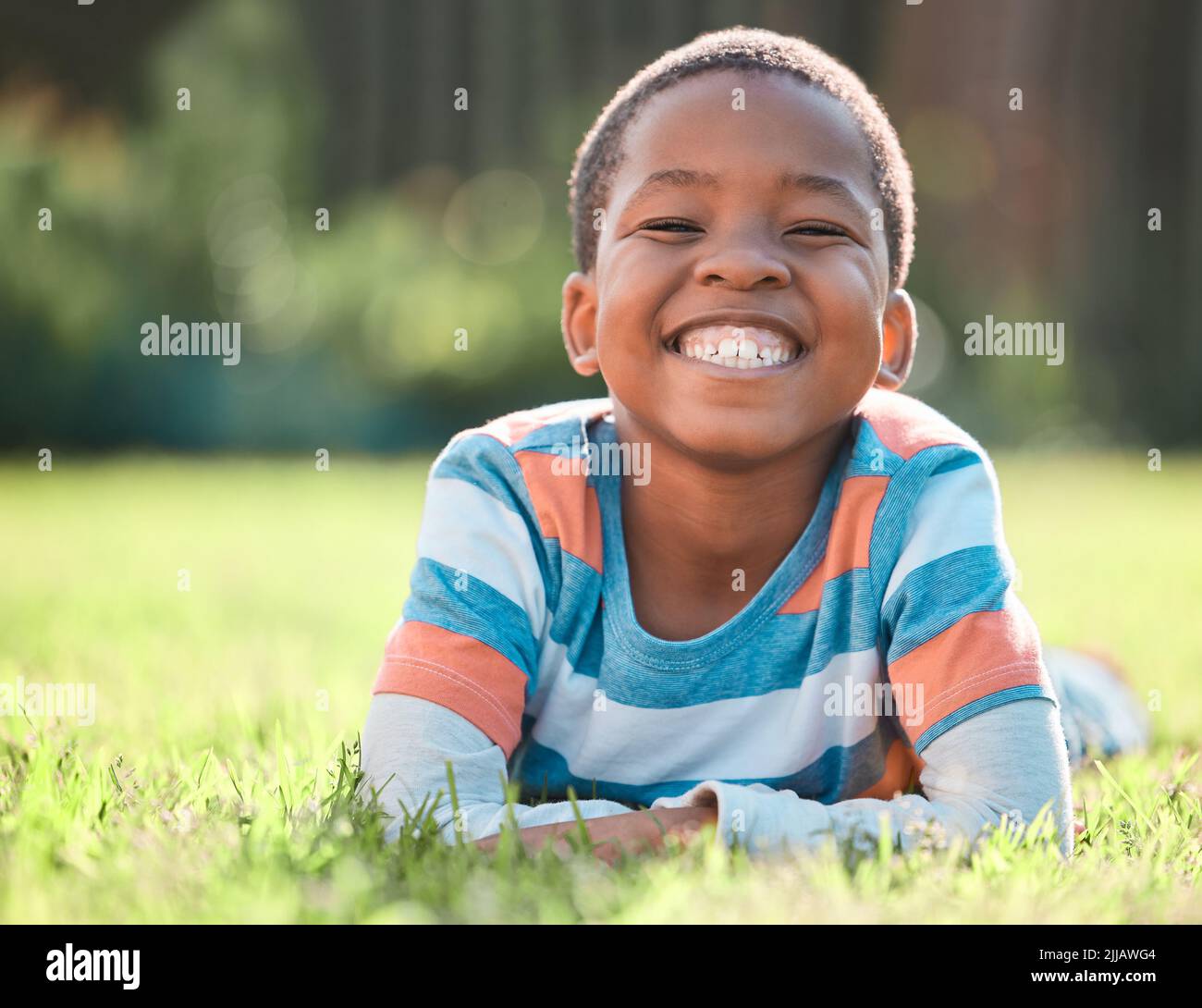 Everyone says that I have the most adorable smile. a young boy lying on ...