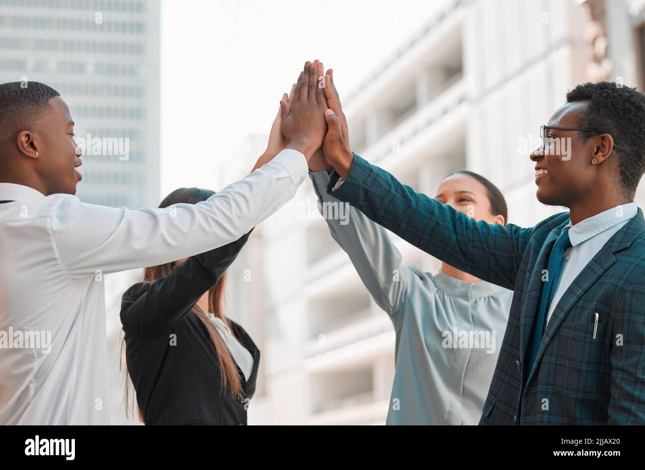 High five for a job well done. a group of businesspeople giving each ...