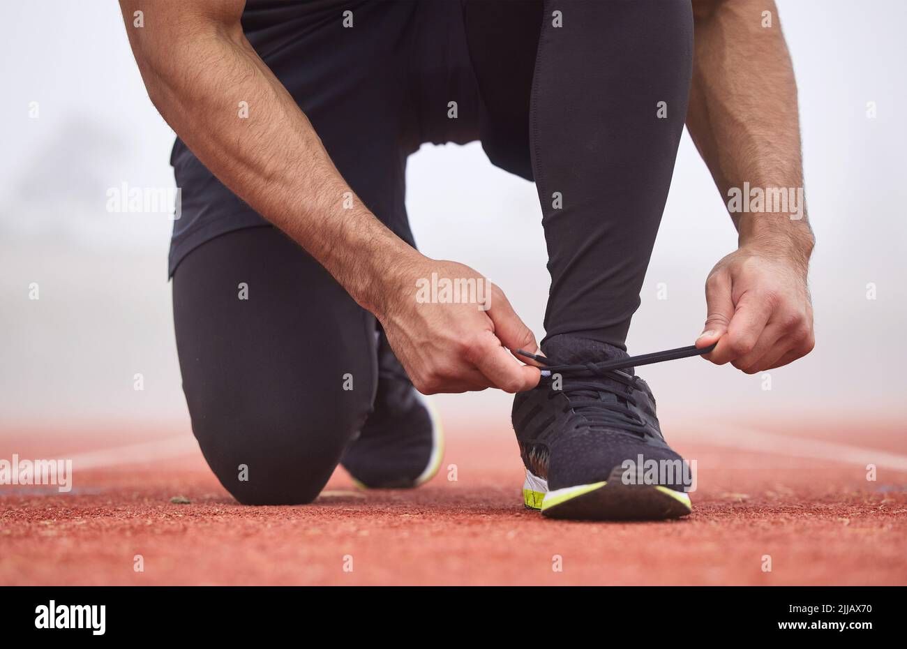 Dont wanna trip over these. an unrecognizable male athlete tying his ...