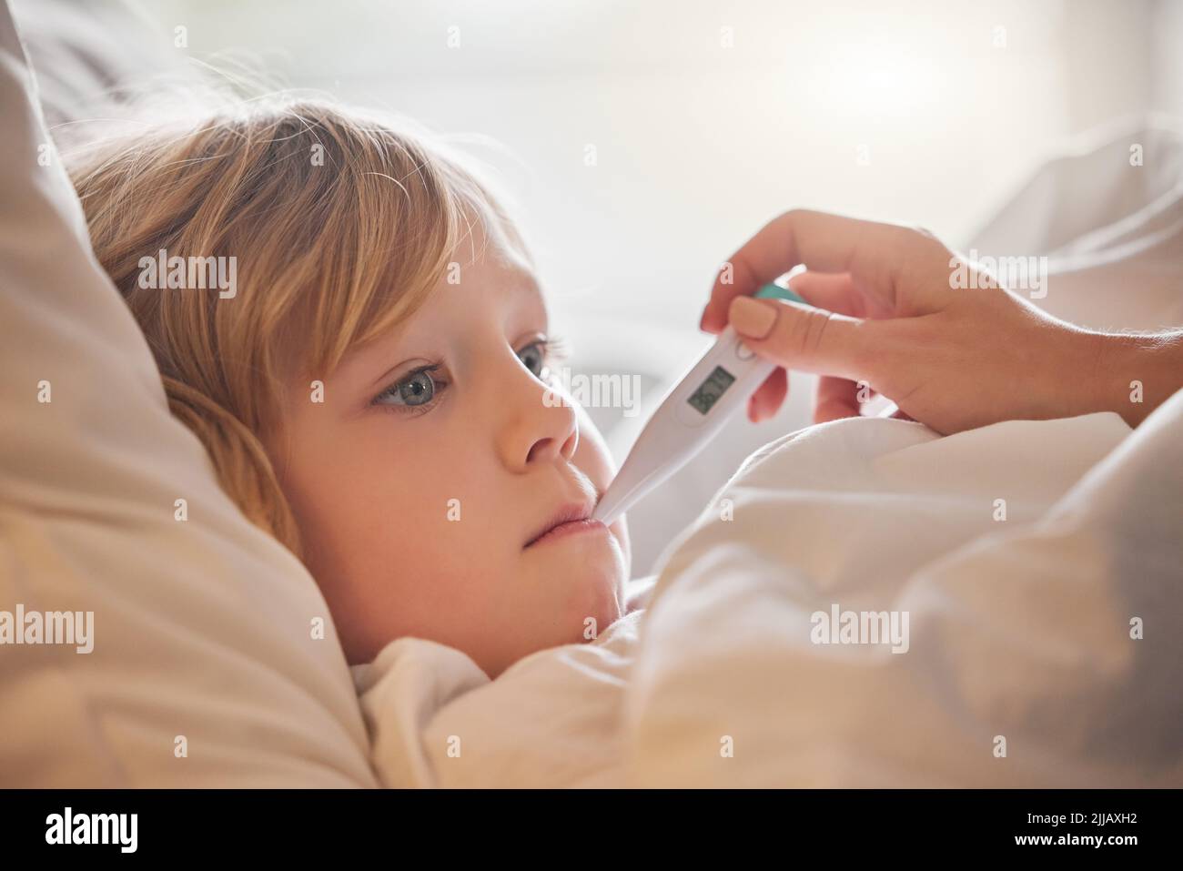 Mommys been checking my temperature often today. an unrecognisable woman taking a little girls ...