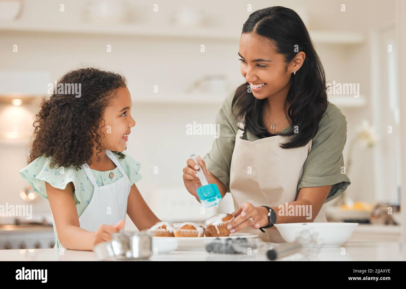 Practicing our art together. a mother and daughter frosting freshly ...