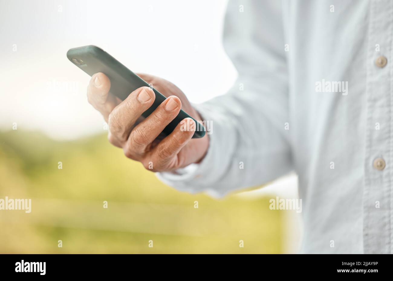 Text as you go. an unrecognizable man using his cellphone while ...