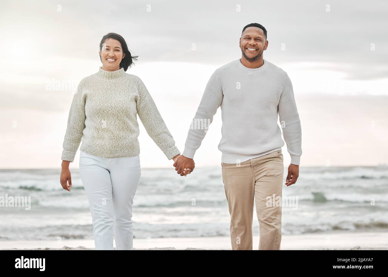 Hand in hand. an affectionate young couple sharing an intimate moment ...