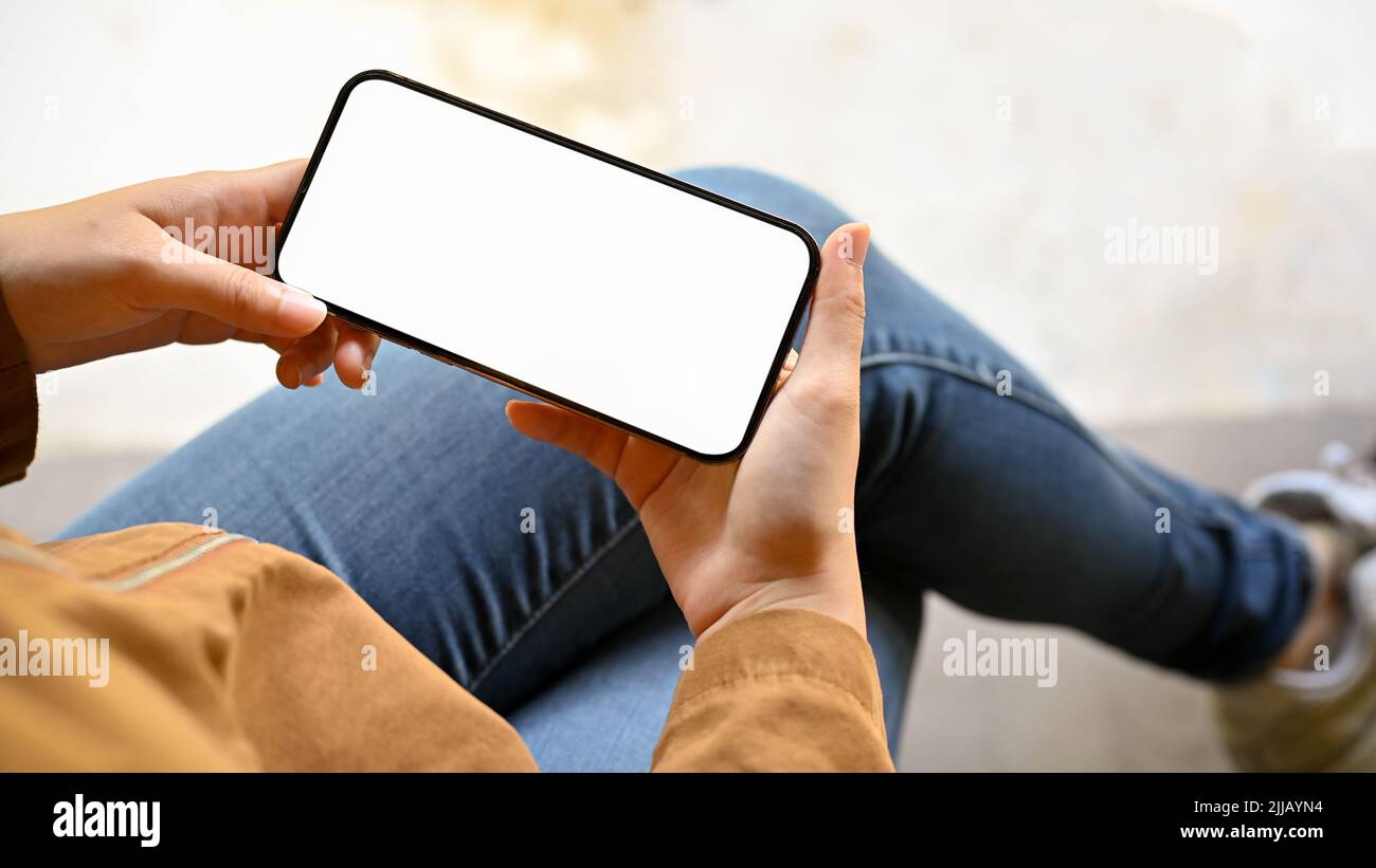 view from above, up close, A woman's hands are holding a mockup of a ...