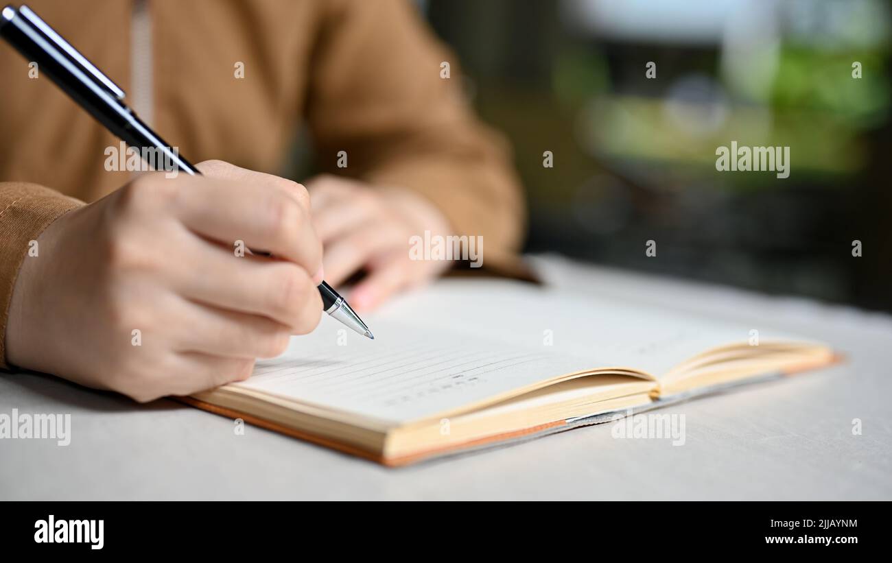 A female college student or school student writing her homework on a ...