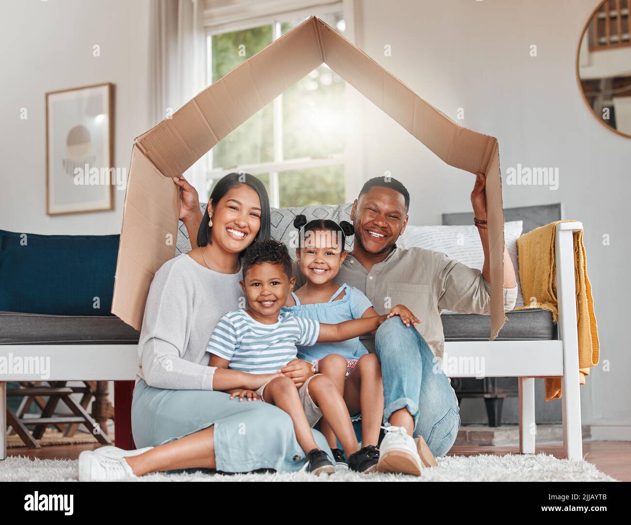 We built a house in our home. Portrait of a young family sitting on the ...