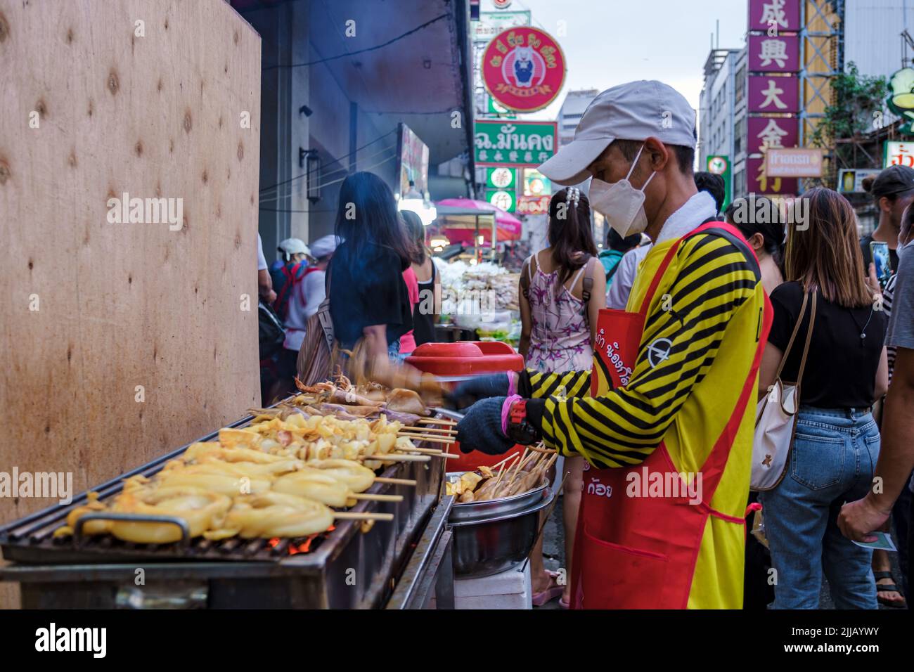 People Grilled squid on a cast iron grill over a charcoal grill ...