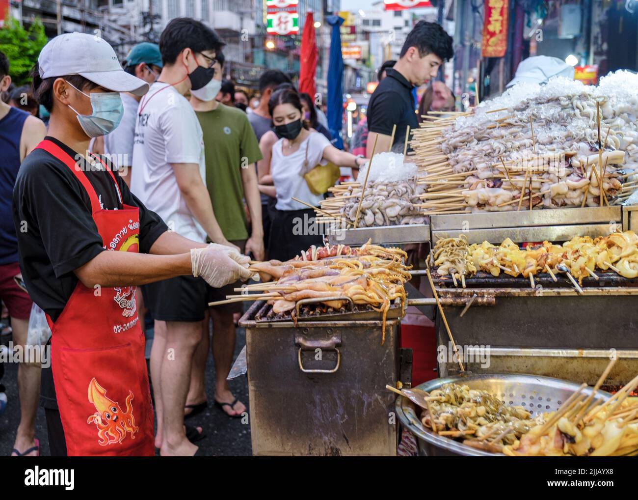 People Grilled squid on a cast iron grill over a charcoal grill ...