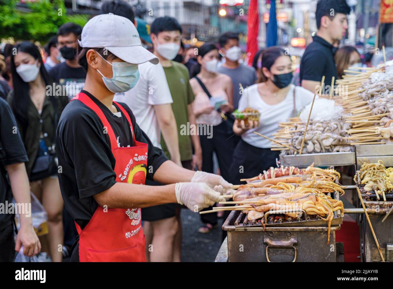 People Grilled squid on a cast iron grill over a charcoal grill ...