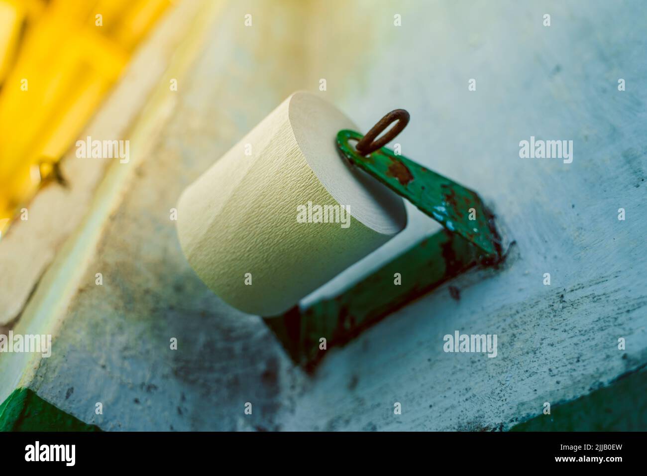 A roll of the cheapest single ply toilet paper on a toilet paper holder ...