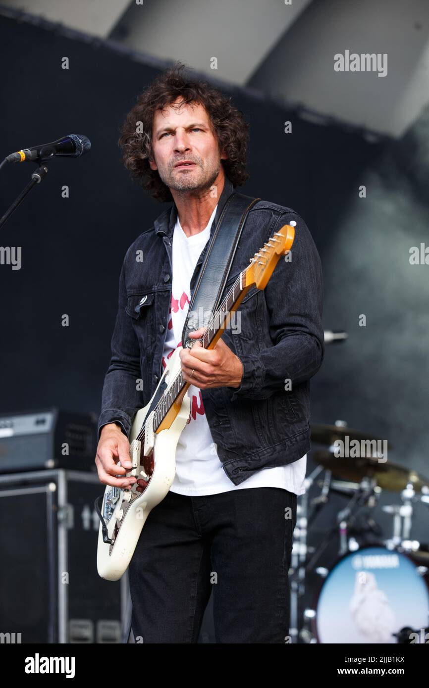 Sam Roberts plays guitar and sings on stage wearing a denim jacket and ...