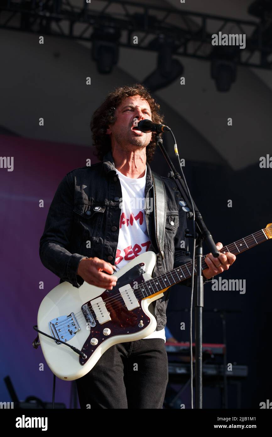 Sam Roberts plays guitar and sings on stage wearing a denim jacket and ...