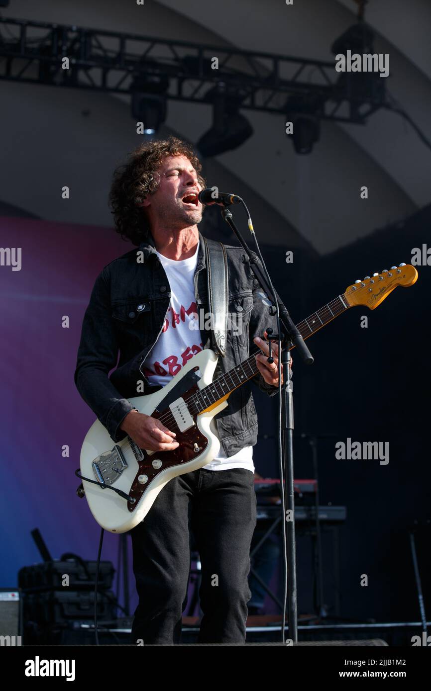 Sam Roberts plays guitar and sings on stage wearing a denim jacket and ...