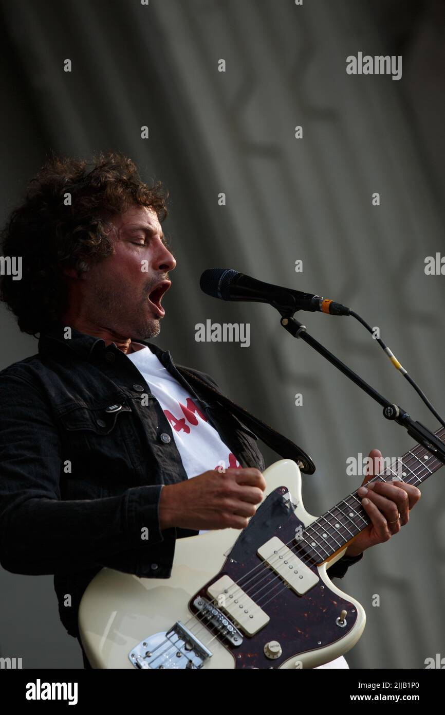 Sam Roberts plays guitar and sings on stage wearing a denim jacket and ...