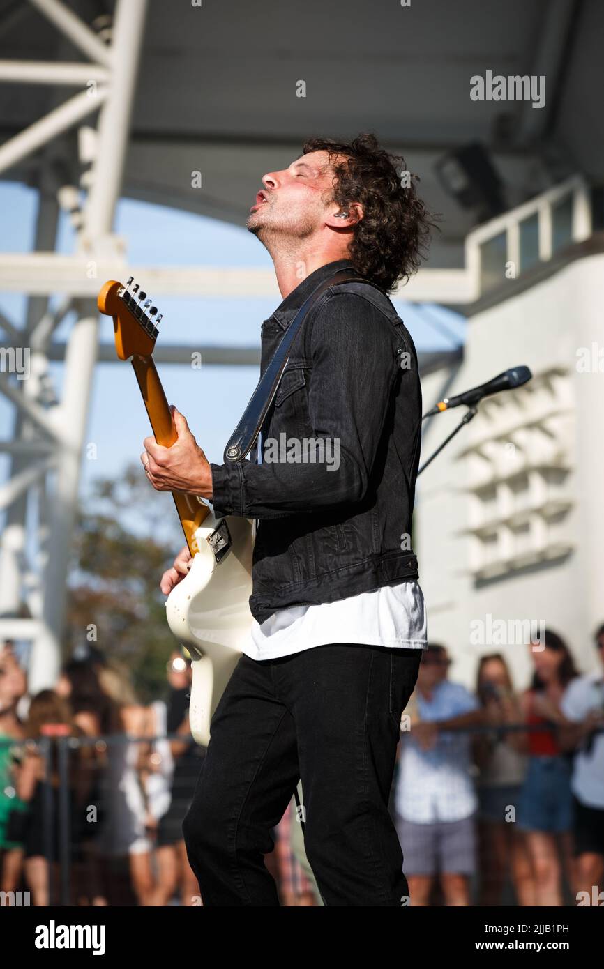 Sam Roberts plays guitar and sings on stage wearing a denim jacket and ...