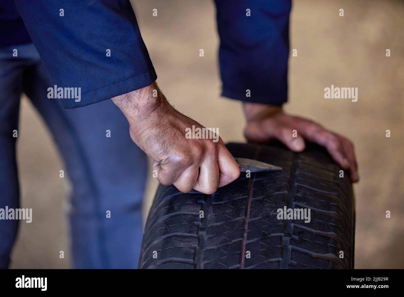 Fixing a puncture. an unrecognizable male mechanic fixing a puncture ...