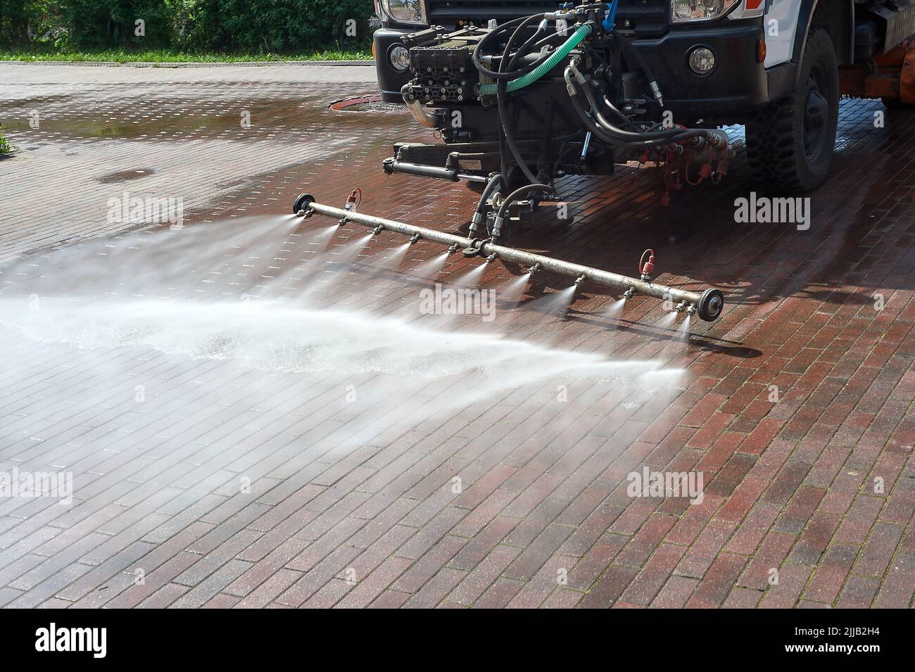 A special machine washes city paths and roads with water Stock Photo ...