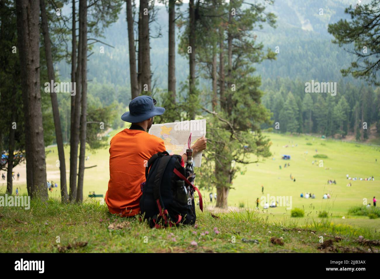 Young Indian Man Traveler with map backpack relaxing outdoor with ...