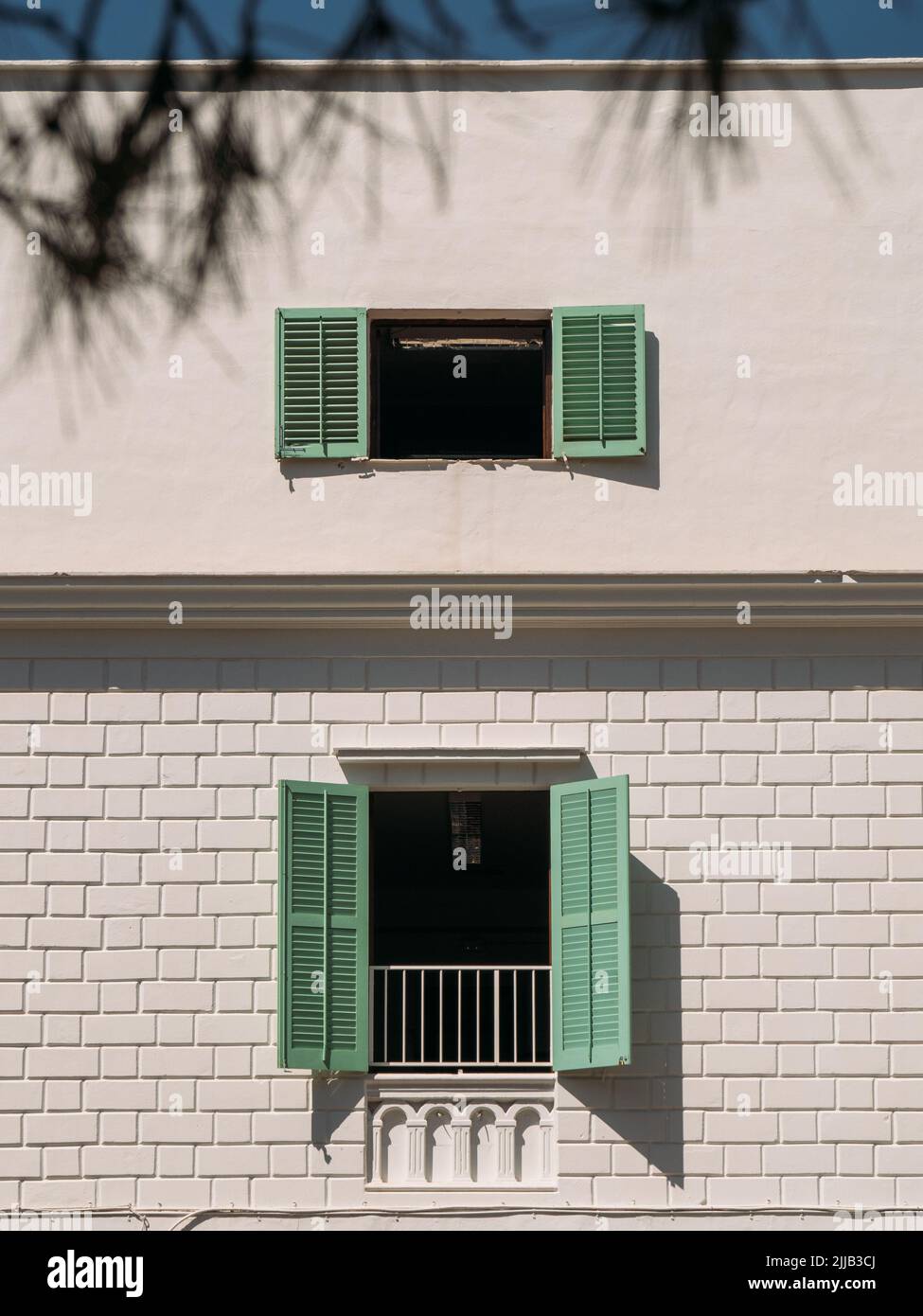 Wooden light green shutters on the window of a typical white house on ...