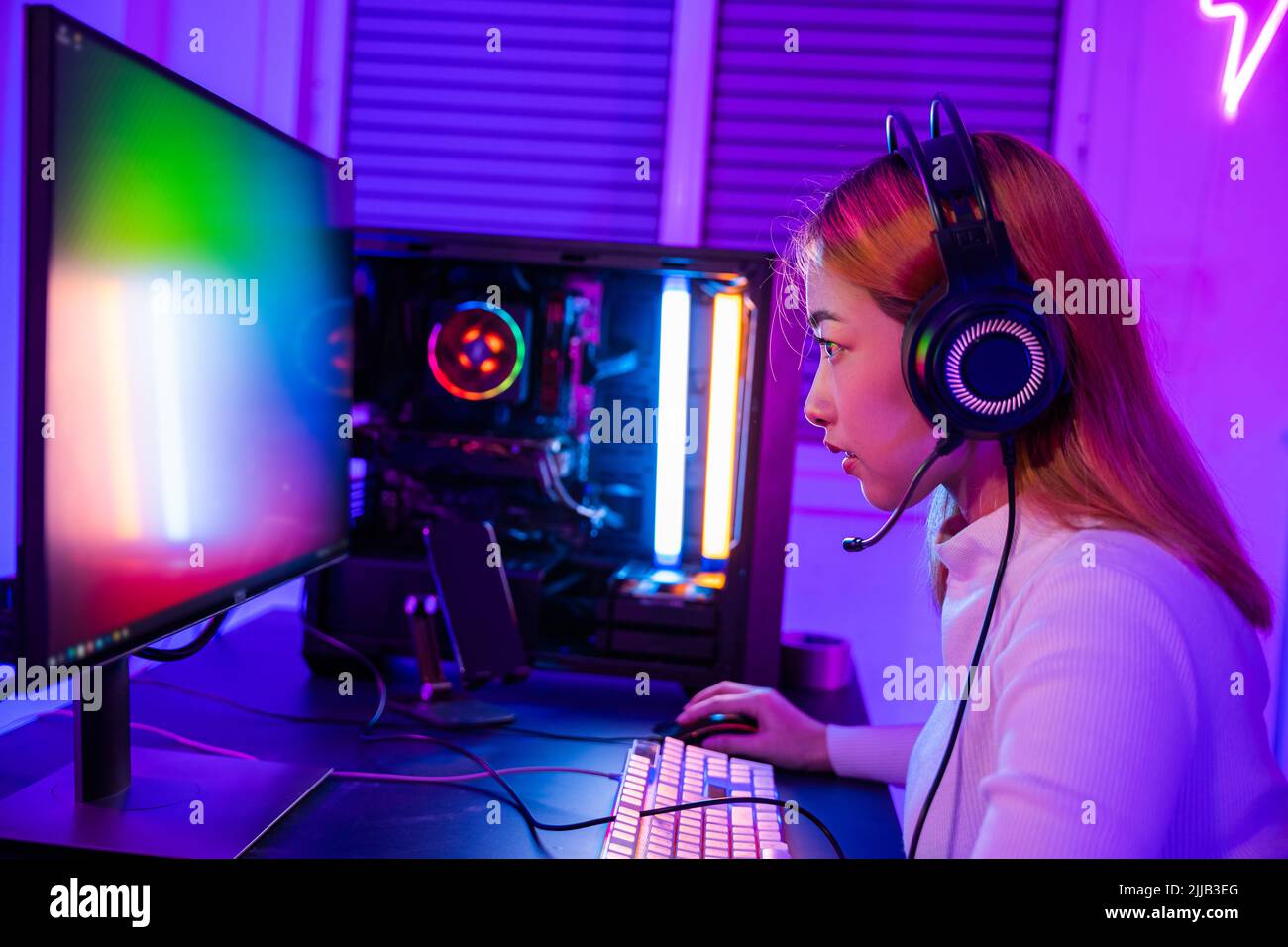 Asian professional gamer playing online video game on desktop computer ...