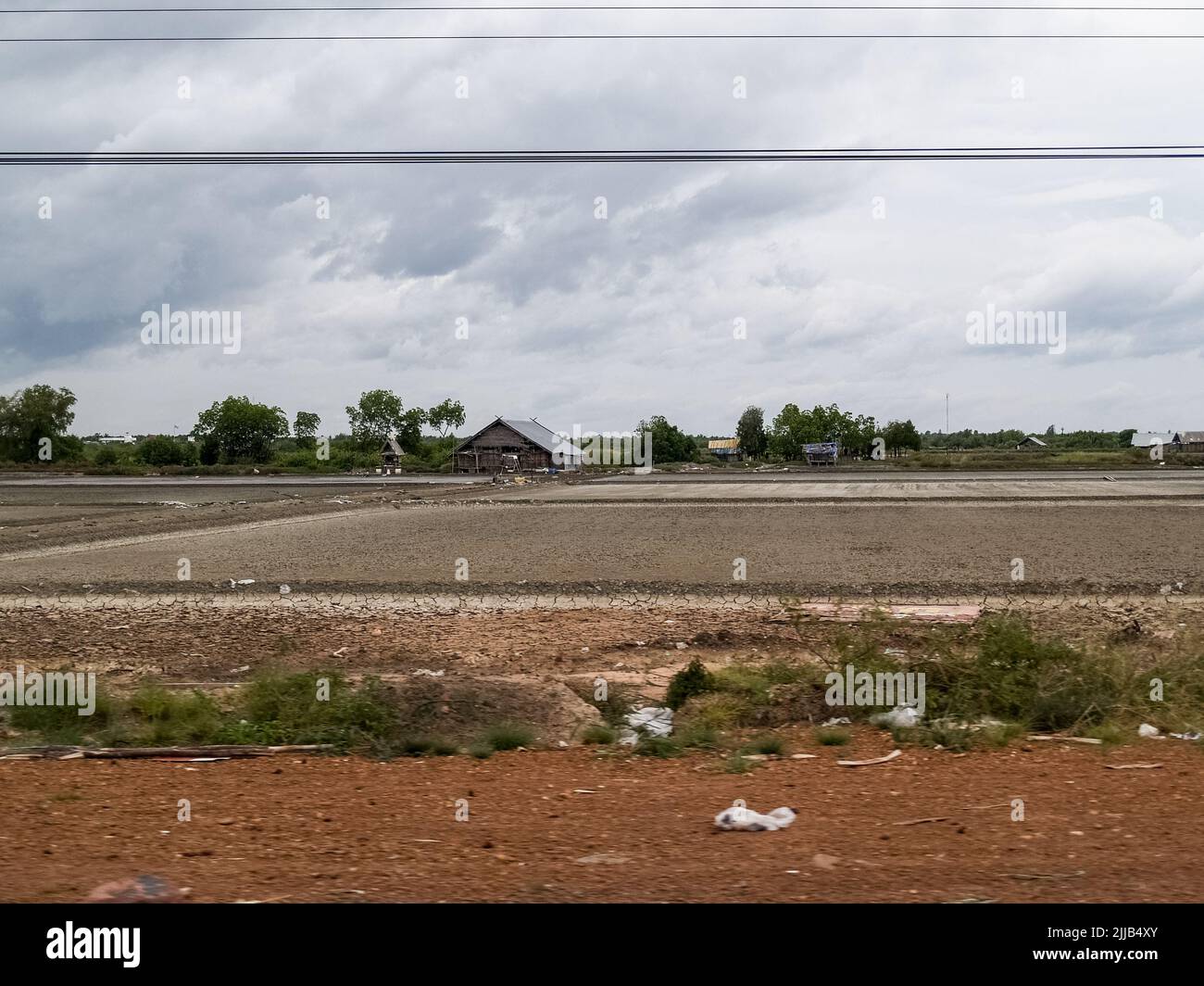 Dry rice paddy fields patterned layout in cracked soil and old shack in ...