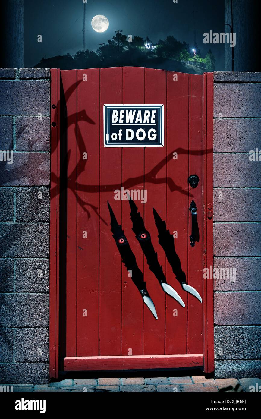 Beast behind a red gate at night Stock Photo - Alamy