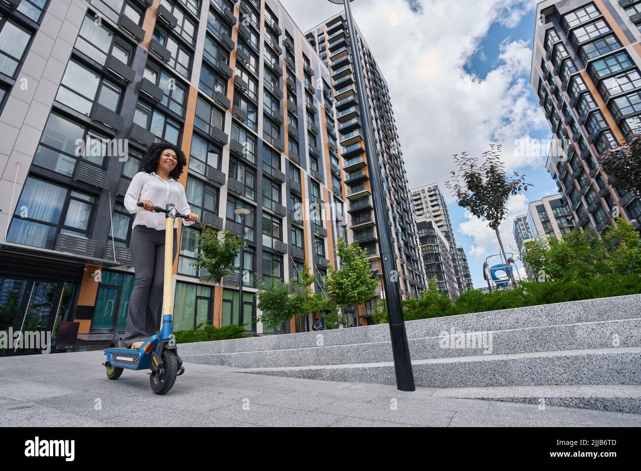 Young multiracial woman riding a scooter around the city Stock Photo ...
