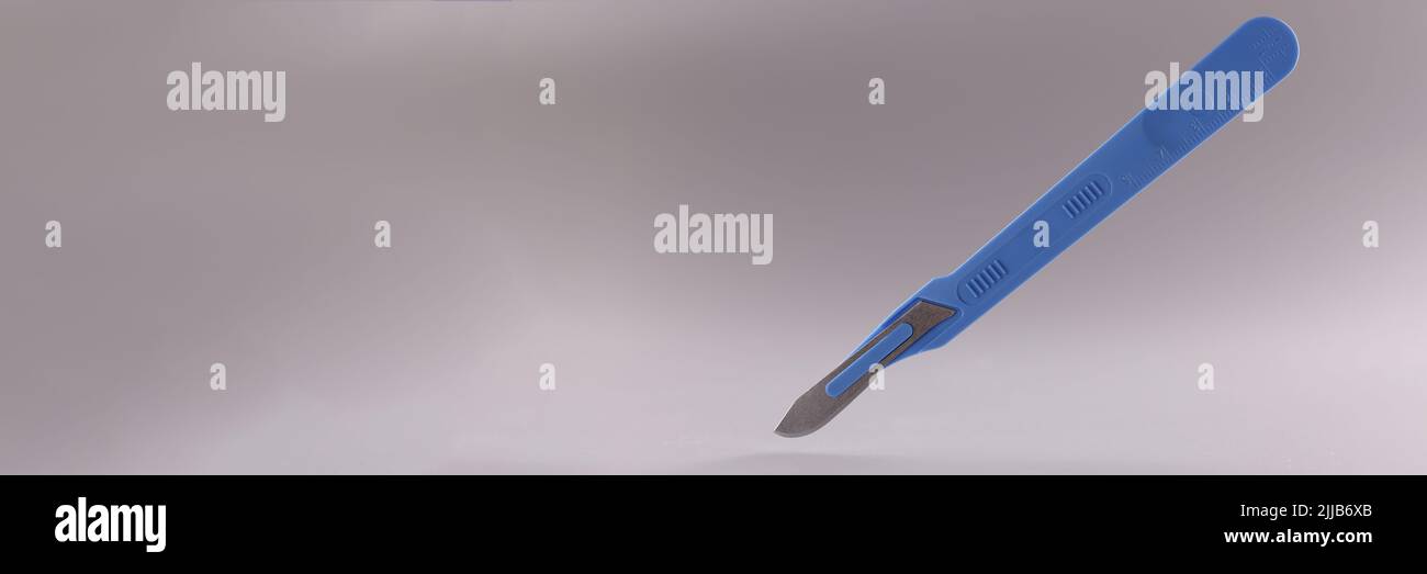 Medical scalpel with blue handle on gray background Stock Photo - Alamy