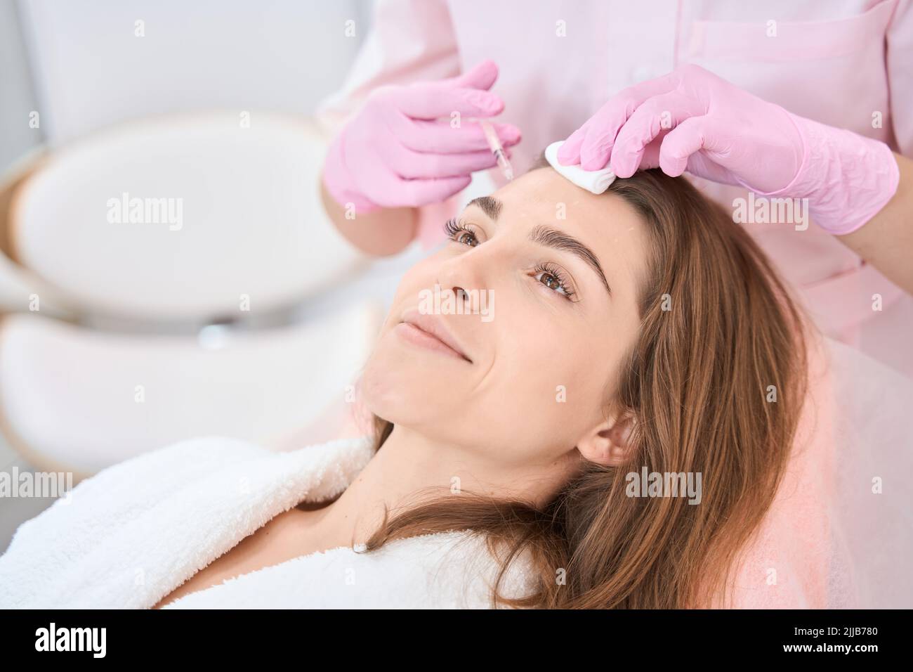 Cosmetologist doing injection procedure on face of a young woman Stock ...