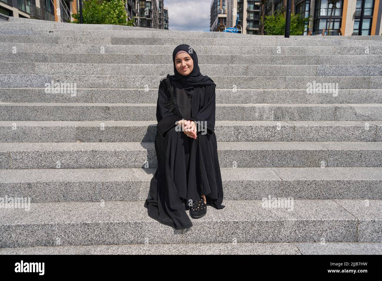 Muslim woman sitting on the stairs while walking in the city Stock ...