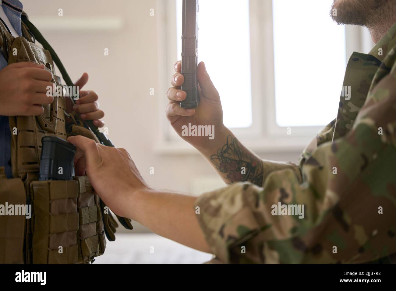 Military man teaching child to handle weapon Stock Photo - Alamy