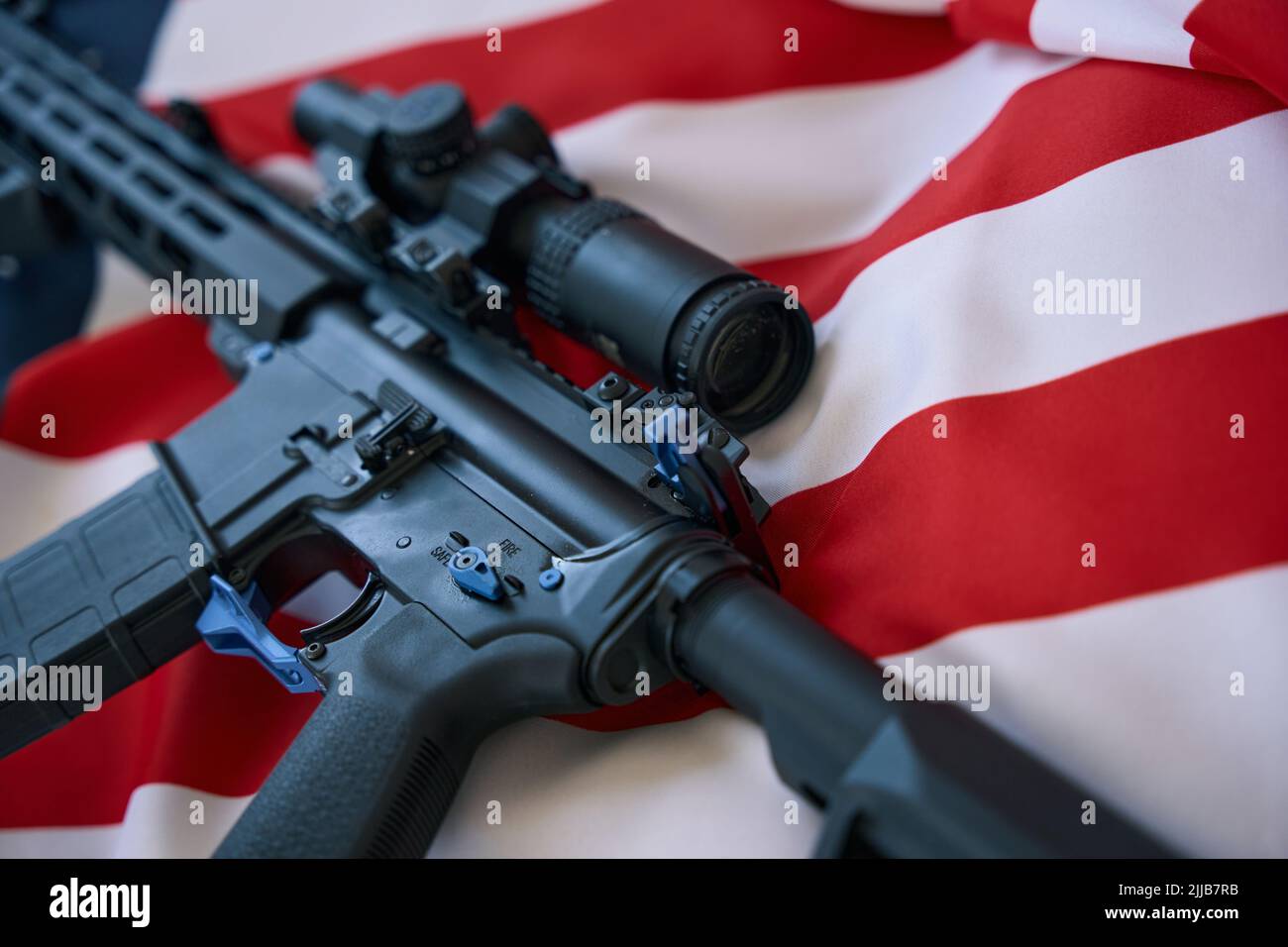 Weapon with telescopic sight lying against American flag Stock Photo ...
