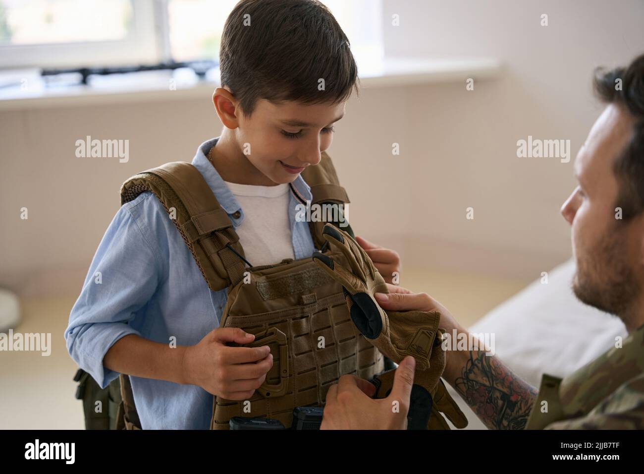 Military man showing army gloves to excited kid Stock Photo - Alamy