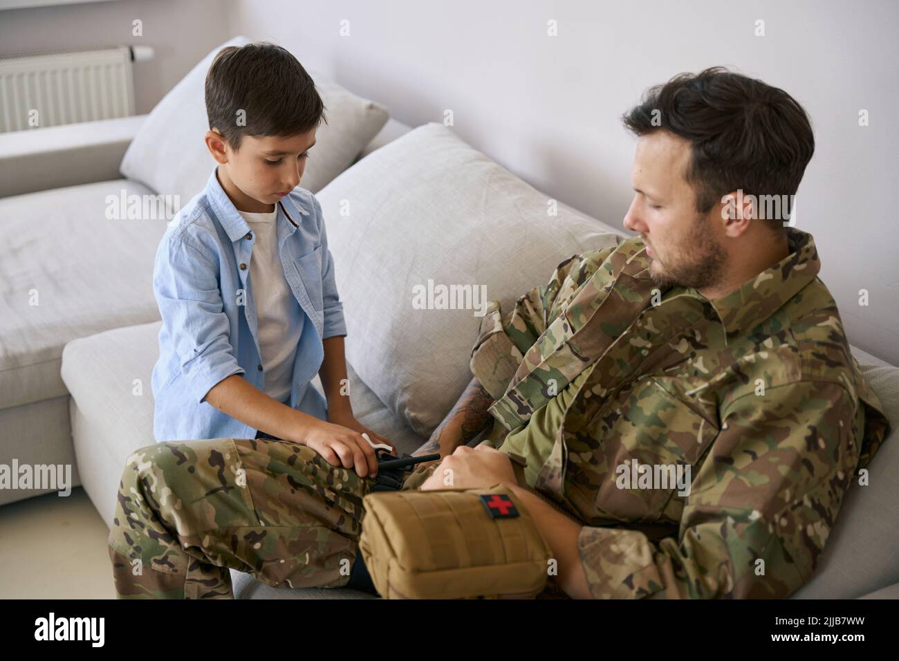 Soldier with first aid kit getting tourniquet from son Stock Photo - Alamy