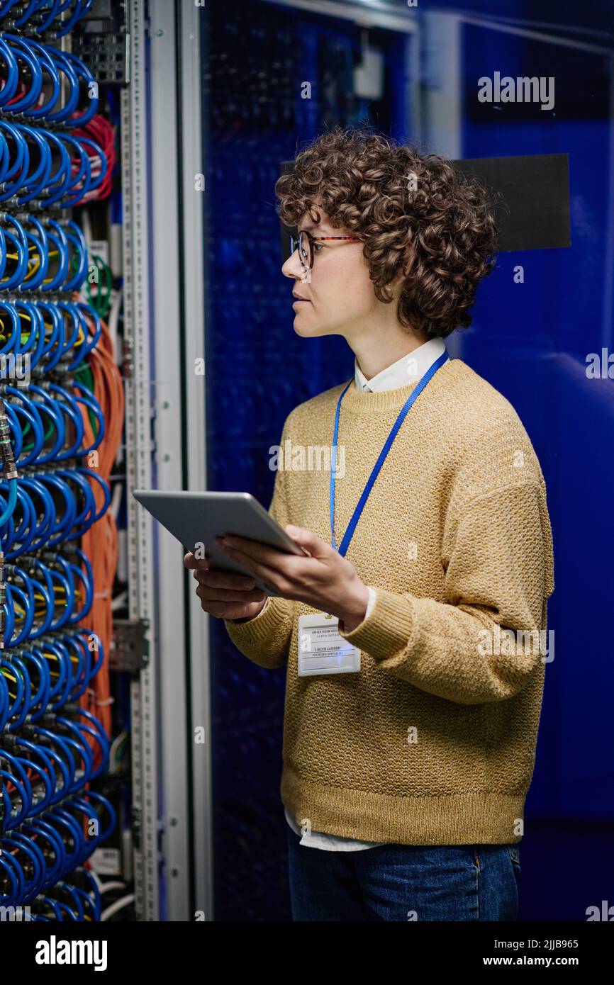 Security specialist controlling the work of computer system with tablet ...