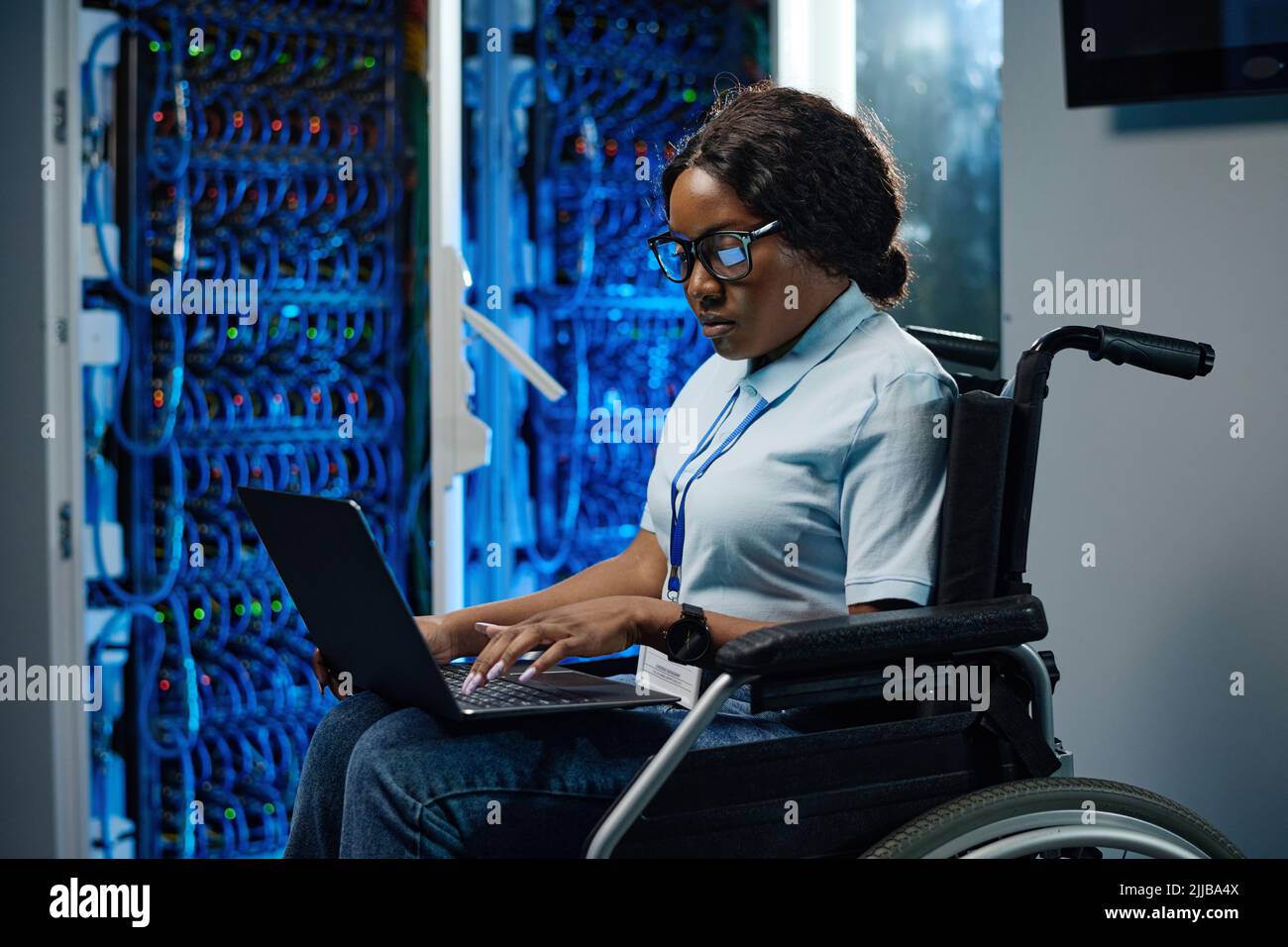 African female IT engineer with disability sitting in wheelchair and ...
